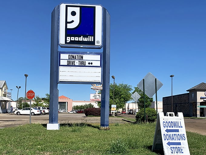 The roadside sign announces both shopping and donation opportunities. The smiling Goodwill logo has become synonymous with second chances.