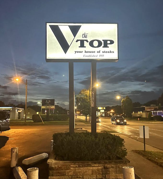 The illuminated sign stands as a beacon in the night, guiding hungry travelers to the promised land of perfect prime rib.