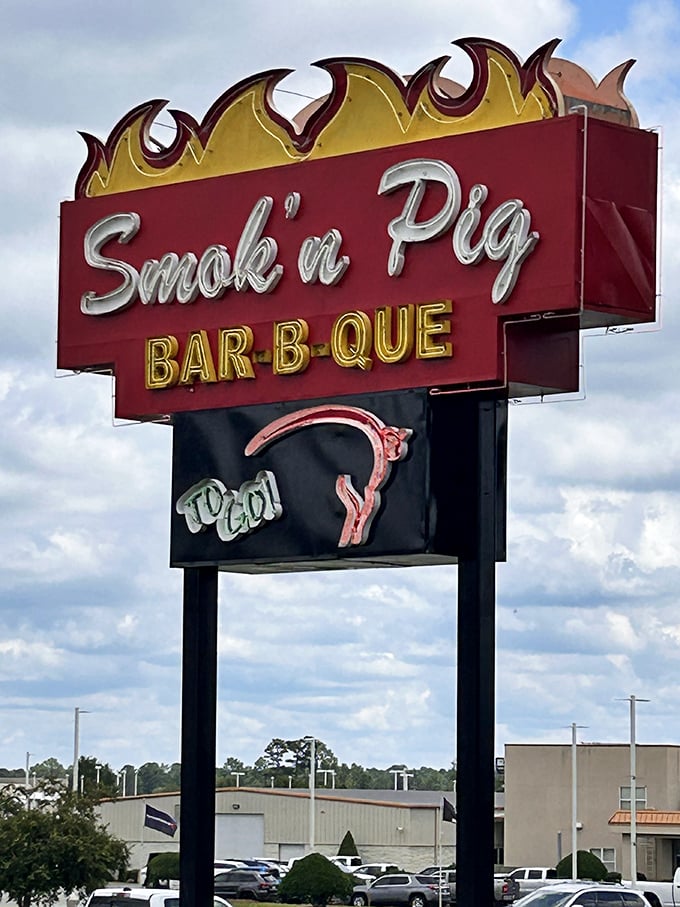 The roadside sign stands tall against the Georgia sky – a beacon of BBQ hope for hungry travelers and locals alike.