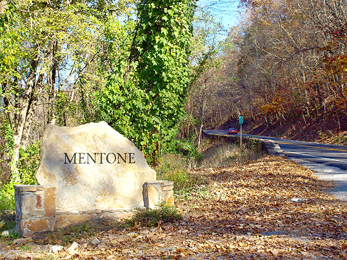 Mentone's entrance stone stands sentinel, autumn leaves scattered like nature's confetti welcoming you to paradise.