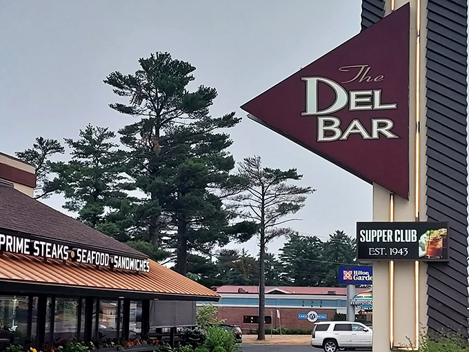 The iconic Del-Bar sign stands tall against Wisconsin skies—a burgundy triangle that points the way to steak nirvana since 1943.