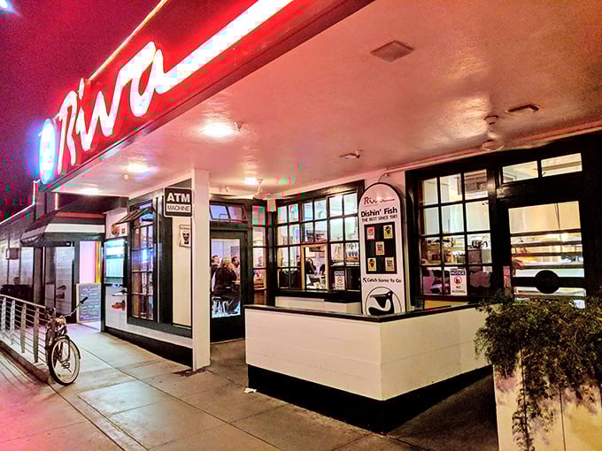 By night, Riva's glowing storefront becomes a lighthouse for hungry souls searching for authentic seafood in Santa Cruz.