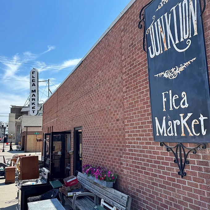The welcoming exterior of Junktion Flea Market, where that elegant sign and brick facade promise adventures in antiquing for those brave enough to enter.