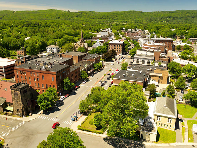 Aerial view of downtown Greenfield, where historic brick buildings meet green mountains – small-town charm with big scenery!