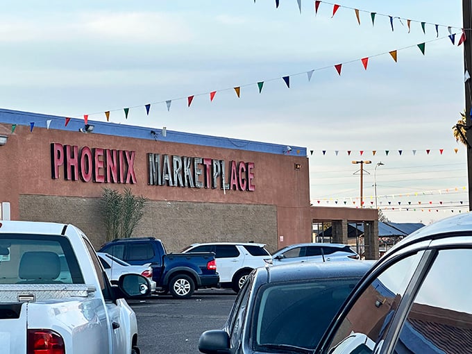 Bargain hunter's paradise! The Phoenix Marketplace stands proud under colorful pennant flags, its mismatched lettering a siren call to treasure seekers braving the Arizona clouds.