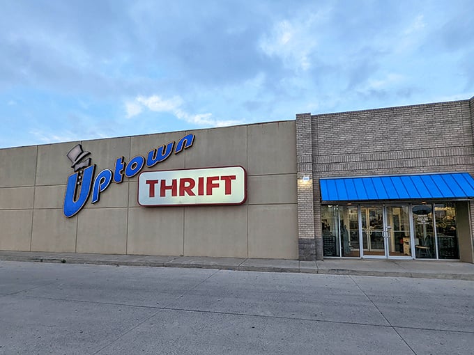 The bright blue Uptown Thrift sign beckons like a neon lighthouse guiding bargain hunters to treasure-filled shores.
