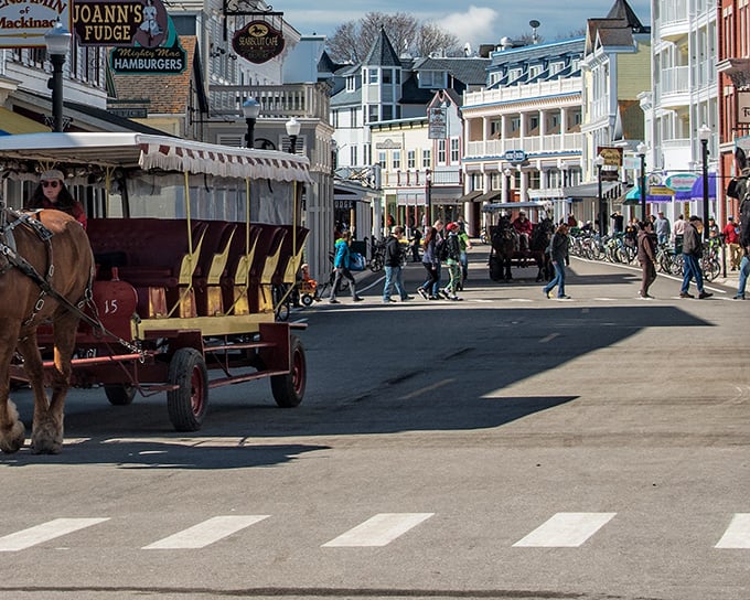 Horse-drawn carriages navigate Victorian streets where the biggest traffic jam involves deciding between chocolate or maple fudge – now that's my kind of rush hour.