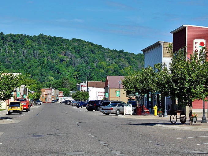Munising's main street nestled against green hills - where nature's majesty meets small-town charm in perfect harmony.