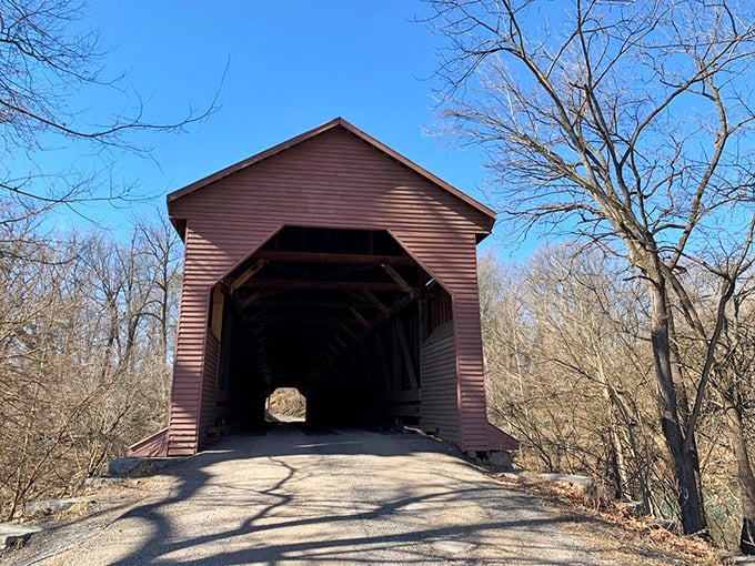 The bridge's entrance beckons like a time portal to simpler days. Those weathered wooden walls have more stories than my grandmother's photo albums.