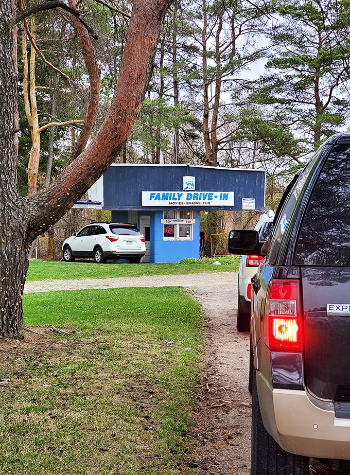 That iconic blue ticket booth welcomes visitors with a promise of "Movies, Snacks, Fun" – the holy trinity of drive-in perfection.