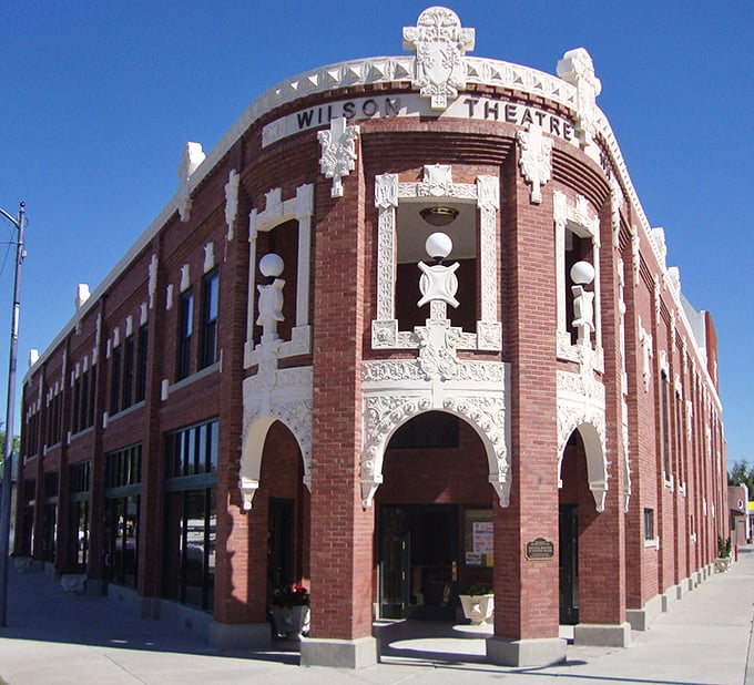 Ornate white detailing frames the Wilson Theatre's brick façade, a testament to an era when even small-town buildings were designed with architectural flair and lasting beauty.