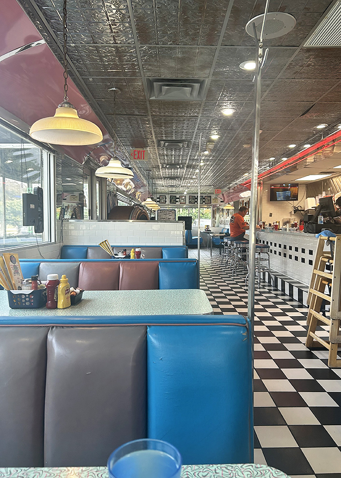 Blue vinyl booths and a checkerboard floor create the perfect backdrop for life-changing conversations over coffee and pie. This isn't decoration—it's diner DNA