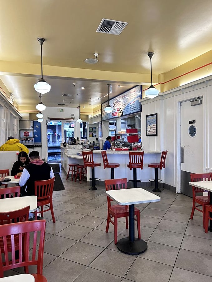 Inside, simplicity reigns supreme with red chairs and pendant lighting creating a cozy backdrop for seafood feasting.