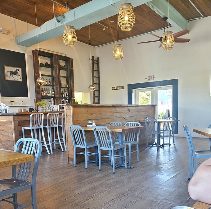 Step inside and discover a rustic-chic interior where wooden beams, wicker pendant lights, and metal chairs create the perfect backdrop for sandwich nirvana.