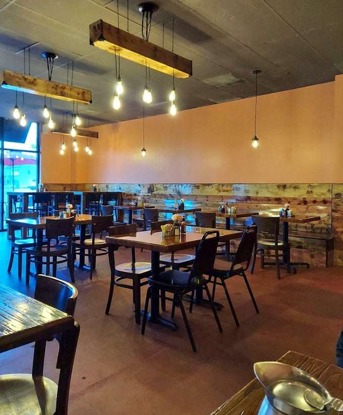 Edison bulbs cast a warm glow over rustic wood accents and comfortable seating. This isn't just a cafe—it's your new favorite living room with better food.