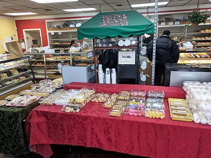 Inside, the bakery's display cases stretch like a treasure map of carbohydrate wonders, with the red tablecloth adding a touch of old-world charm.