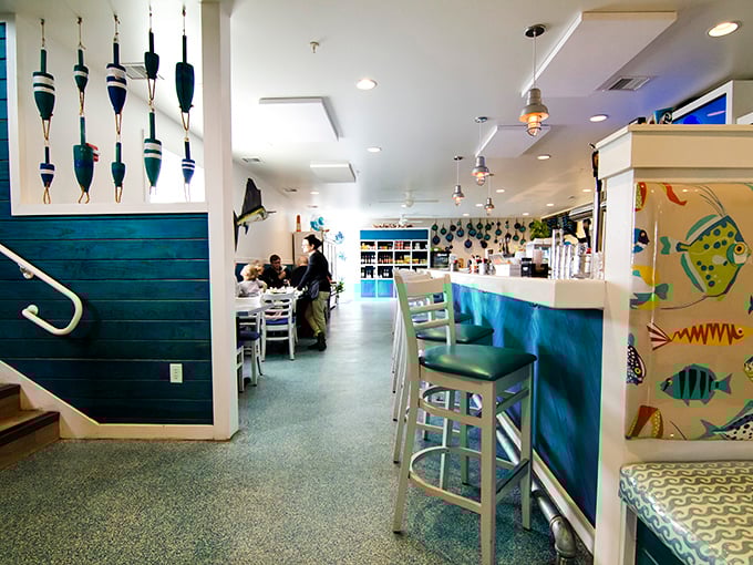 Fishing floats dangle from the ceiling while turquoise accents create the perfect nautical backdrop. You're not just in a restaurant—you're in a coastal escape.