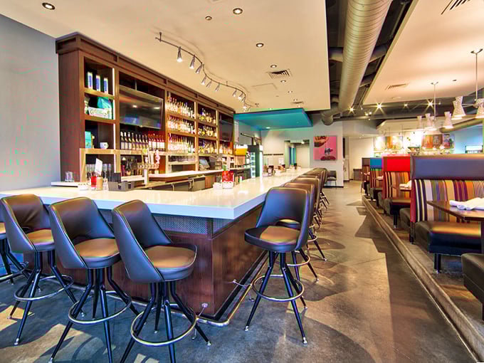 Mid-century modern meets brunch paradise. The sleek bar area invites you to sip mimosas while plotting your cheese curd strategy.
