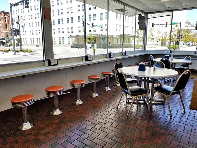 Classic counter seating with those iconic orange-topped stools – where strangers become friends over shared appreciation of perfect sandwiches.