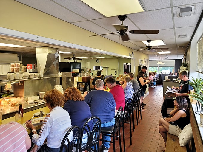 Counter seating offers front-row views to culinary magic while ceiling fans gently circulate aromas that make waiting for a table worthwhile.
