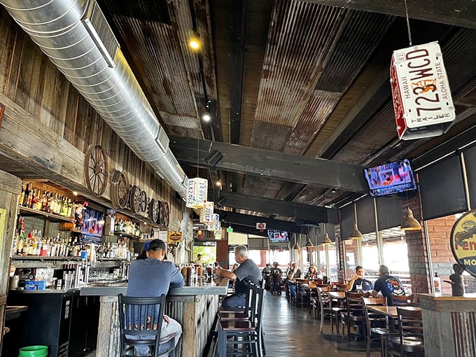Industrial meets rustic in this interior where corrugated metal ceilings and exposed ductwork create the perfect backdrop for serious barbecue business.