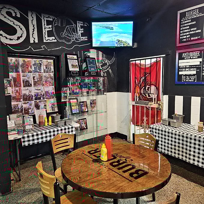 The black walls adorned with sports memorabilia create the perfect backdrop for the real star of the show—those magnificent burgers.