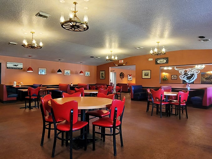 Wagon wheel chandeliers and vibrant orange walls create the perfect backdrop for meat-centric memories. This isn't designer chic—it's comfort with character!