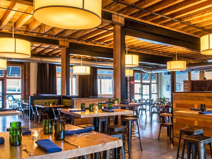 Wooden beams, warm lighting, and industrial-chic design create the perfect backdrop for conversations that flow as smoothly as the craft beers.