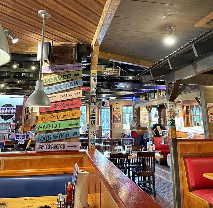 Colorful directional signs point to destinations across America, creating a whimsical roadmap overhead that makes dining feel like a cross-country adventure.