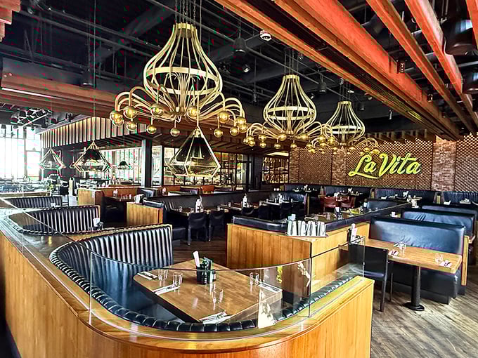 Those golden chandeliers aren't just lighting fixtures—they're conversation starters hanging above curved booths designed for lingering dinners and endless stories.