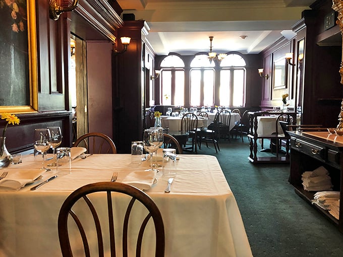 Dark wood paneling and crisp white tablecloths create an atmosphere that whispers, "Put your phone away and savor this moment."
