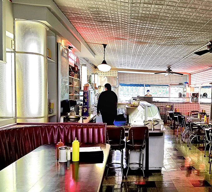 Step inside and the pressed tin ceiling, cherry-red booths, and vintage counter stools whisper stories of decades past. This isn't retro-styled—it's authentically preserved.