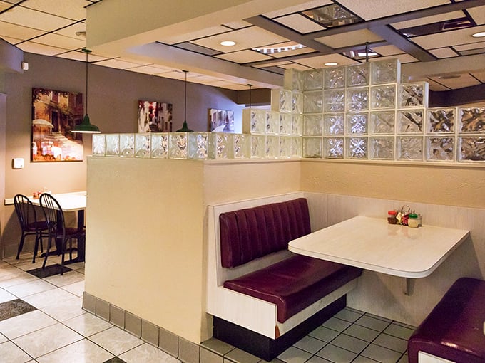 Those burgundy vinyl booths and glass block dividers aren't just retro—they're time machines to when conversations happened without phones.