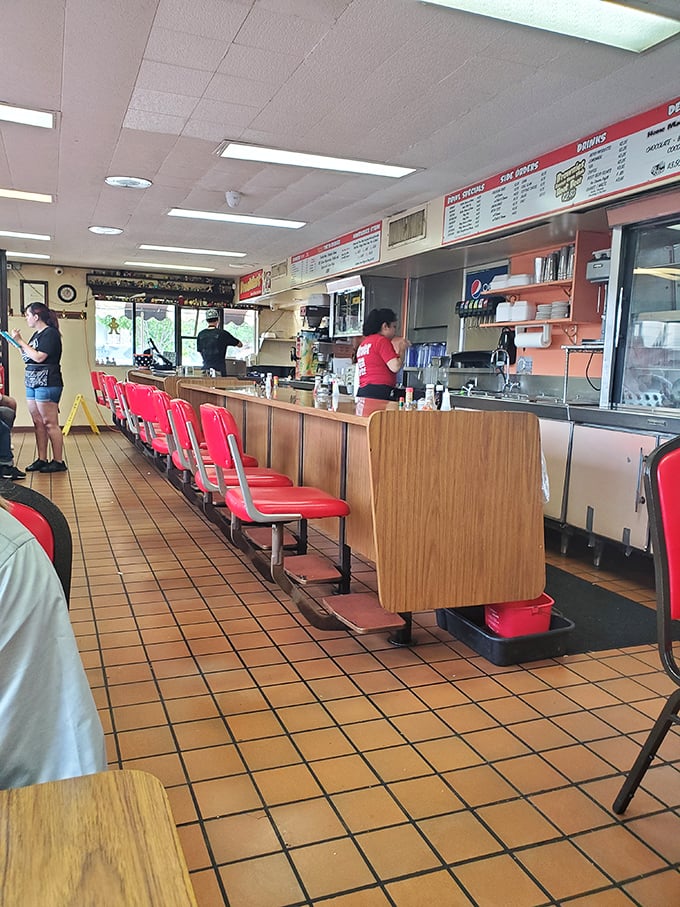 The counter seating at Brownie's is burger theater in the round—front row tickets to the sizzle show that's been running longer than most Broadway hits.