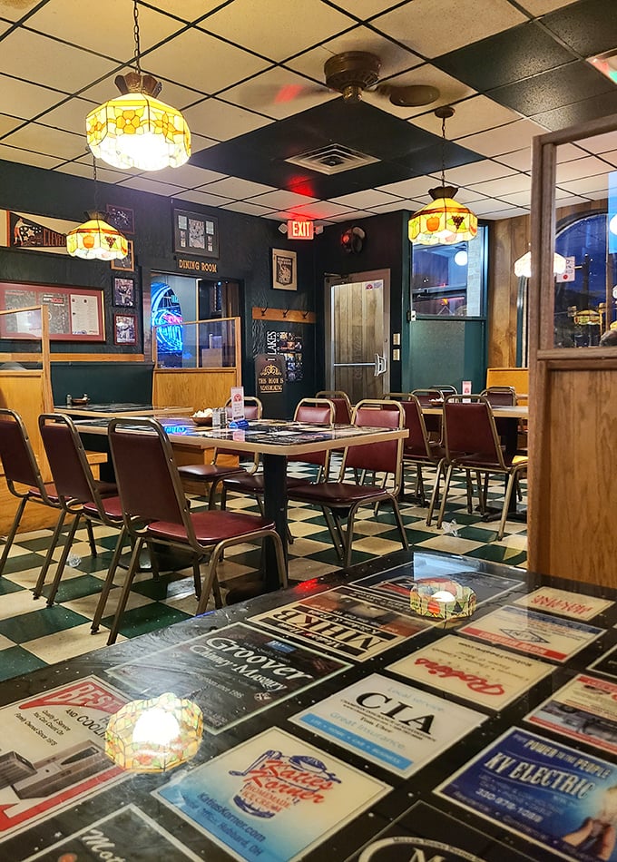Classic Tiffany-style lamps cast a warm glow over the checkered floor – dining ambiance that's remained deliciously unchanged for decades.