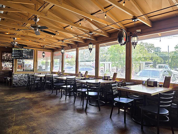 Sunlight streams through large windows, illuminating wooden ceiling beams and creating a rustic-modern vibe that says "stay awhile."