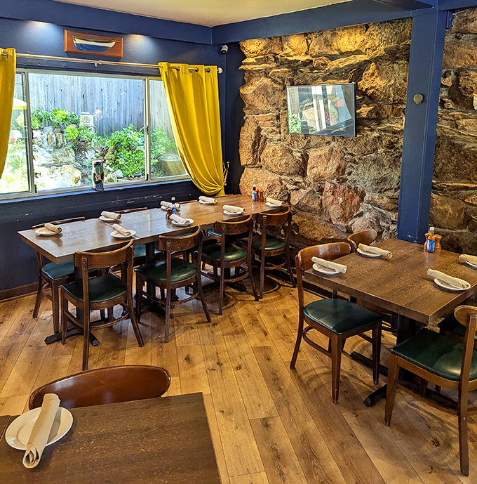 Stone walls that could tell a thousand tales of coastal storms embrace wooden tables where countless celebrations have unfolded. Those yellow curtains? Pure California sunshine.