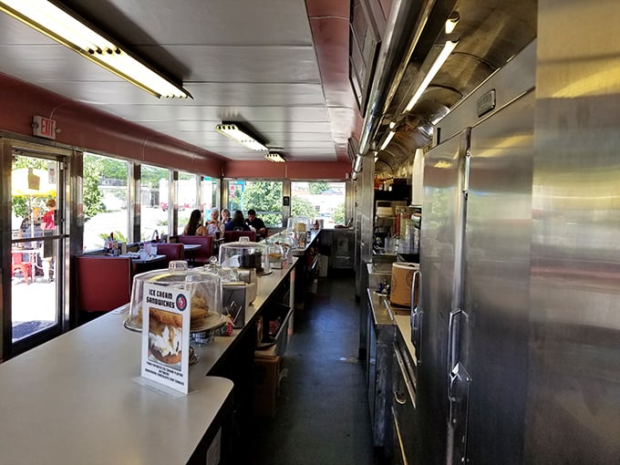 Classic diner geometry at its finest—a narrow galley kitchen where culinary magic happens just inches from your counter seat, close enough to witness breakfast alchemy.