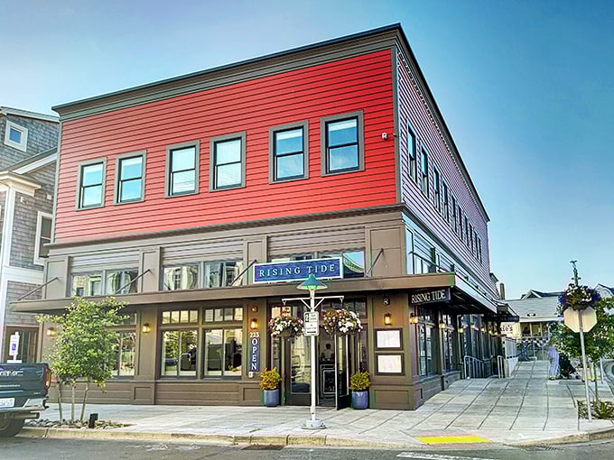The Rising Tide Tavern stands proud in its crimson glory, like a lighthouse for the hungry, beckoning weary travelers with promises of cold brews and hot meals.