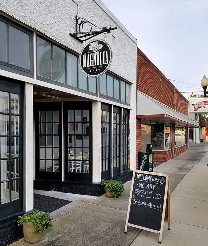 The Magnolia Cafe beckons with its charming storefront and inviting chalkboard sign – a downtown gem where locals gather for homemade comfort and conversation.