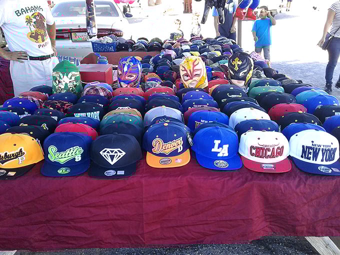 A rainbow of team loyalty spread across the table—baseball caps representing cities, dreams, and the occasional questionable fashion choice.