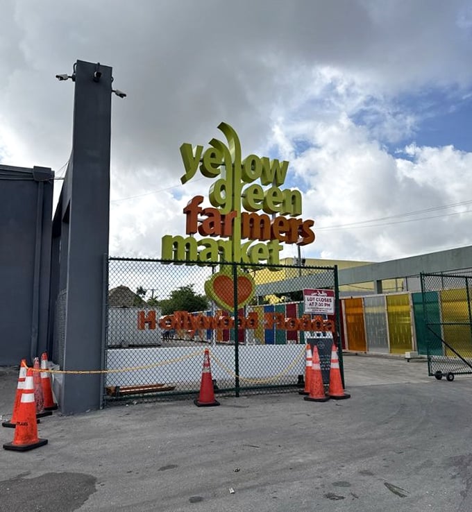 The market's colorful entrance sign promises what lies beyond—a world where "farmers market" is less a description and more an understatement.