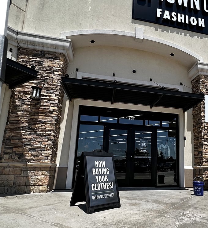 "Now Buying Your Clothes!" The entrance beckons with stone accents and clean lines—far from the cluttered thrift stores of yesteryear.