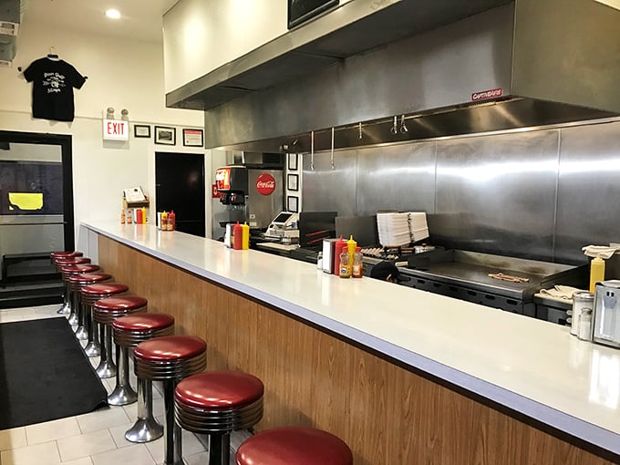 Classic red vinyl stools lined up like soldiers, ready for the next wave of hungry patrons seeking solace in eggs and coffee.