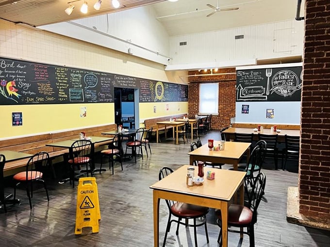 Exposed brick meets cheerful yellow walls in this dining space where chalkboard menus showcase daily specials with artistic flair – comfort food with a side of creativity.