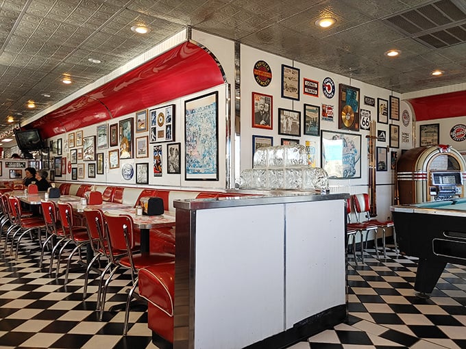 Step inside and the past comes alive – red vinyl booths, checkered floors, and walls adorned with memories of an era when Elvis was king and milkshakes were a food group.