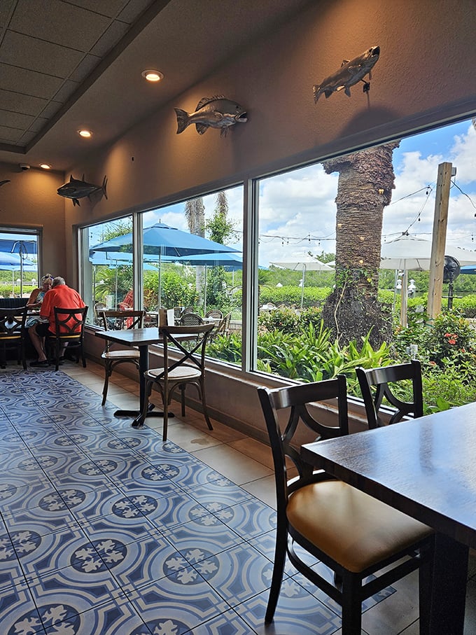 Fish mounts watch over diners like culinary guardian angels while floor-to-ceiling windows frame nature's artwork—Florida's waterways and swaying palms.
