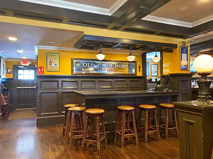 The interior strikes that perfect pub balance – dark wood, golden walls, and just enough room between stools for friendly conversation to bloom.