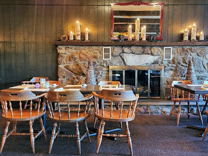 Wooden captain's chairs surround tables facing a magnificent stone fireplace. This isn't just rustic charm—it's the stage where steak dreams become delicious reality.