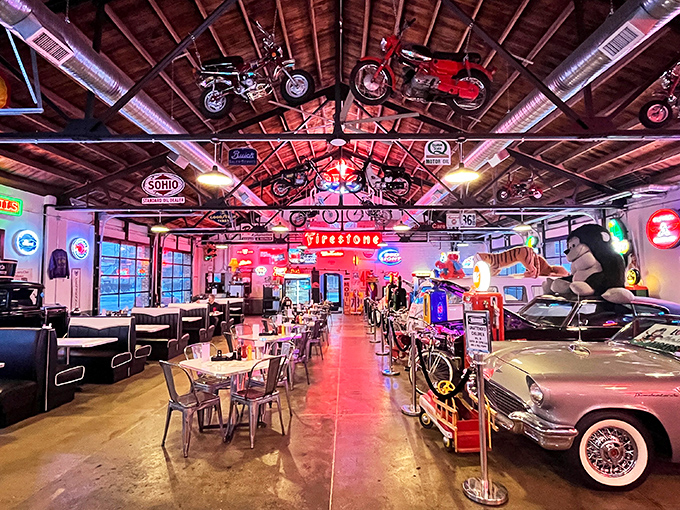 Vintage motorcycles suspended from wooden rafters and classic cars parked inside—this isn't just a diner, it's a time machine with table service.